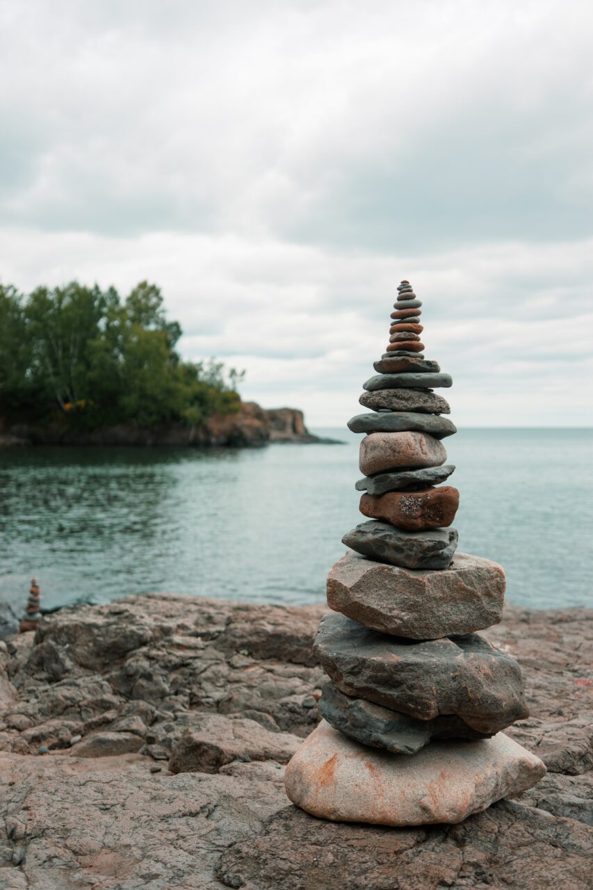 Balanced Stone Stack on Rocky Shore Tranquil Sea Wallpaper | Background ...