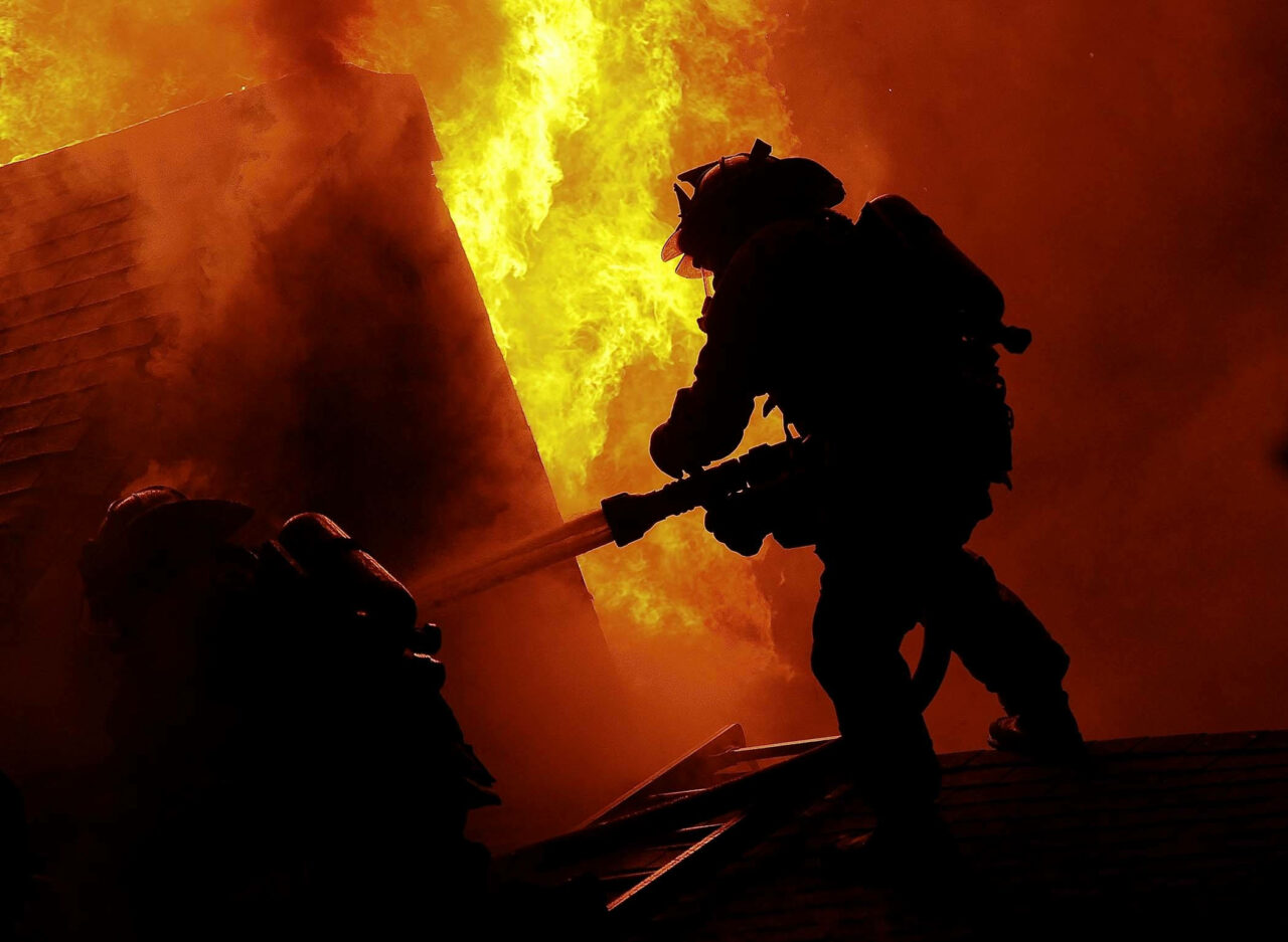 Brave Firefighter Fighting Flames in Dark Night Wallpaper | Background ...
