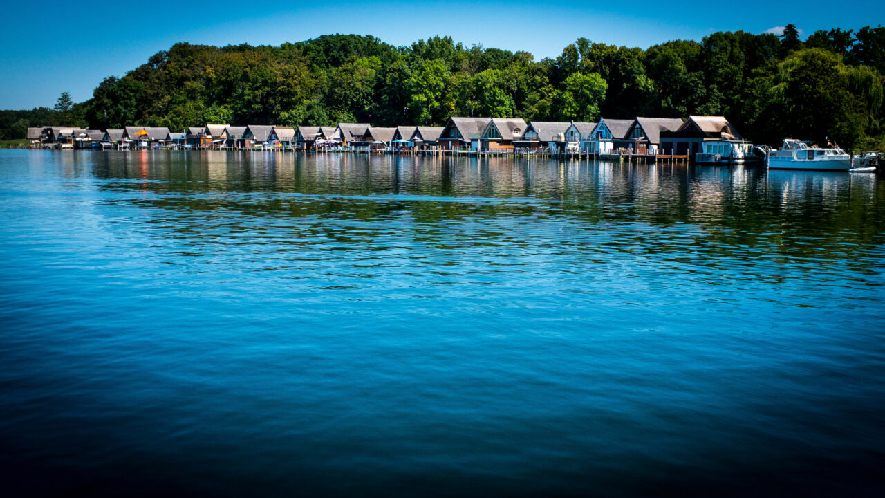 Tranquil Lakeside Houses and Blue Sky Waterfront Wallpaper | Background ...