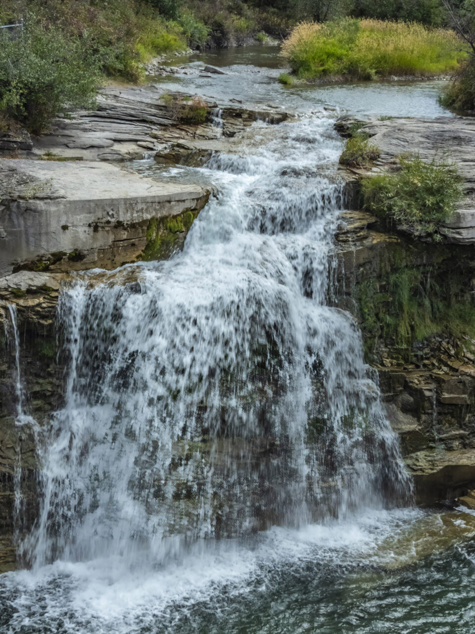 Tranquil Waterfall Over Stones with Lush Greenery Wallpaper ...