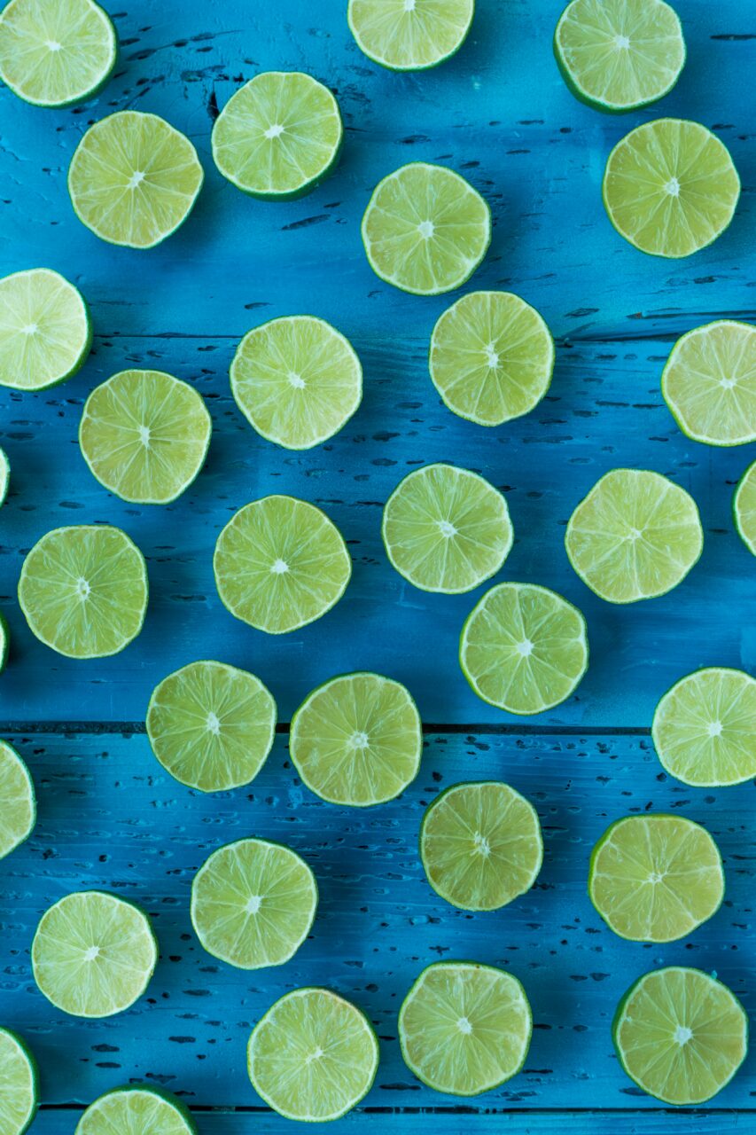Zesty Lime Arrangement on Textured Blue Wallpaper | Background FREE ...
